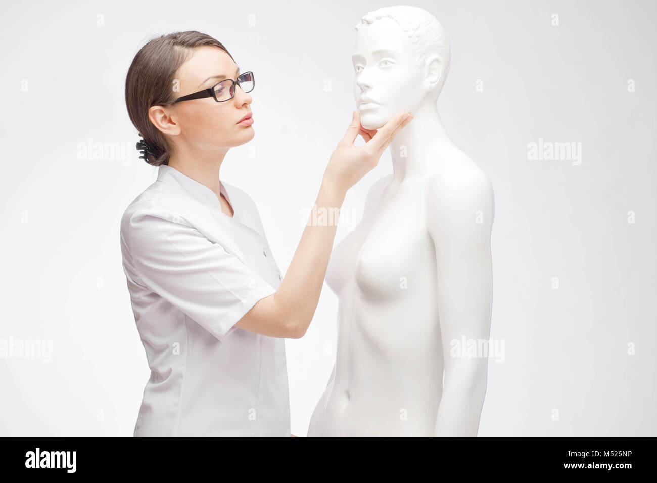 Young doctor observes a human mannequin on isolated background Stock ...