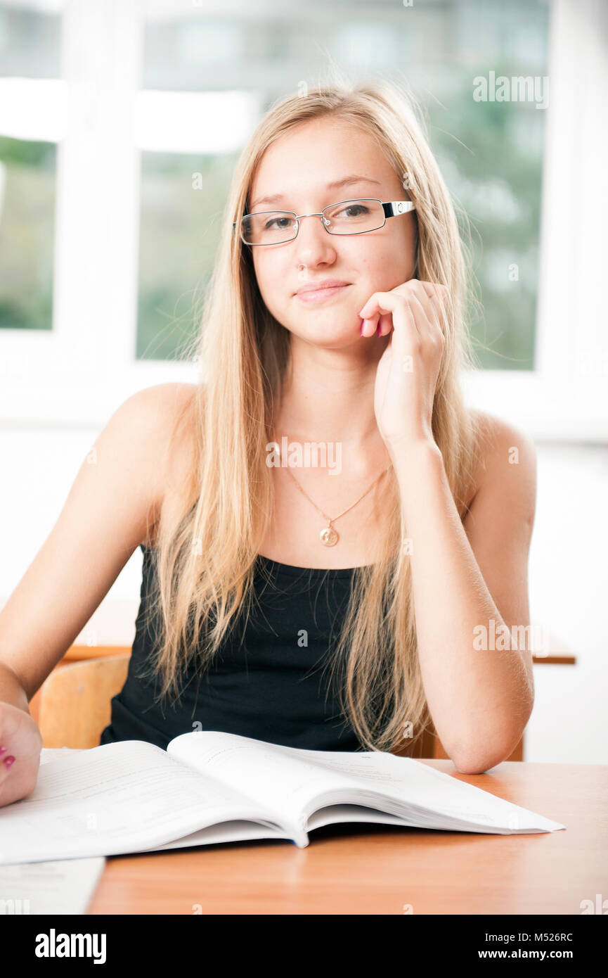 Young blonde student reading at her desk Stock Photo - Alamy