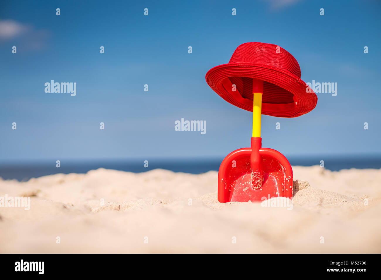 Red shovel and straw hat on the beach Stock Photo - Alamy