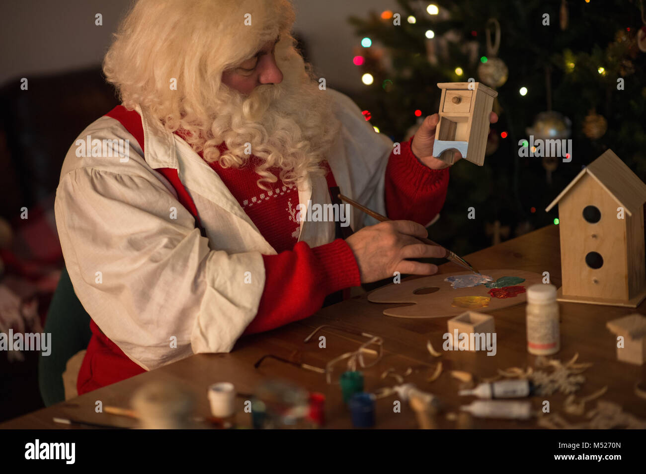 Santa Claus at Home making toys and painting Stock Photo - Alamy