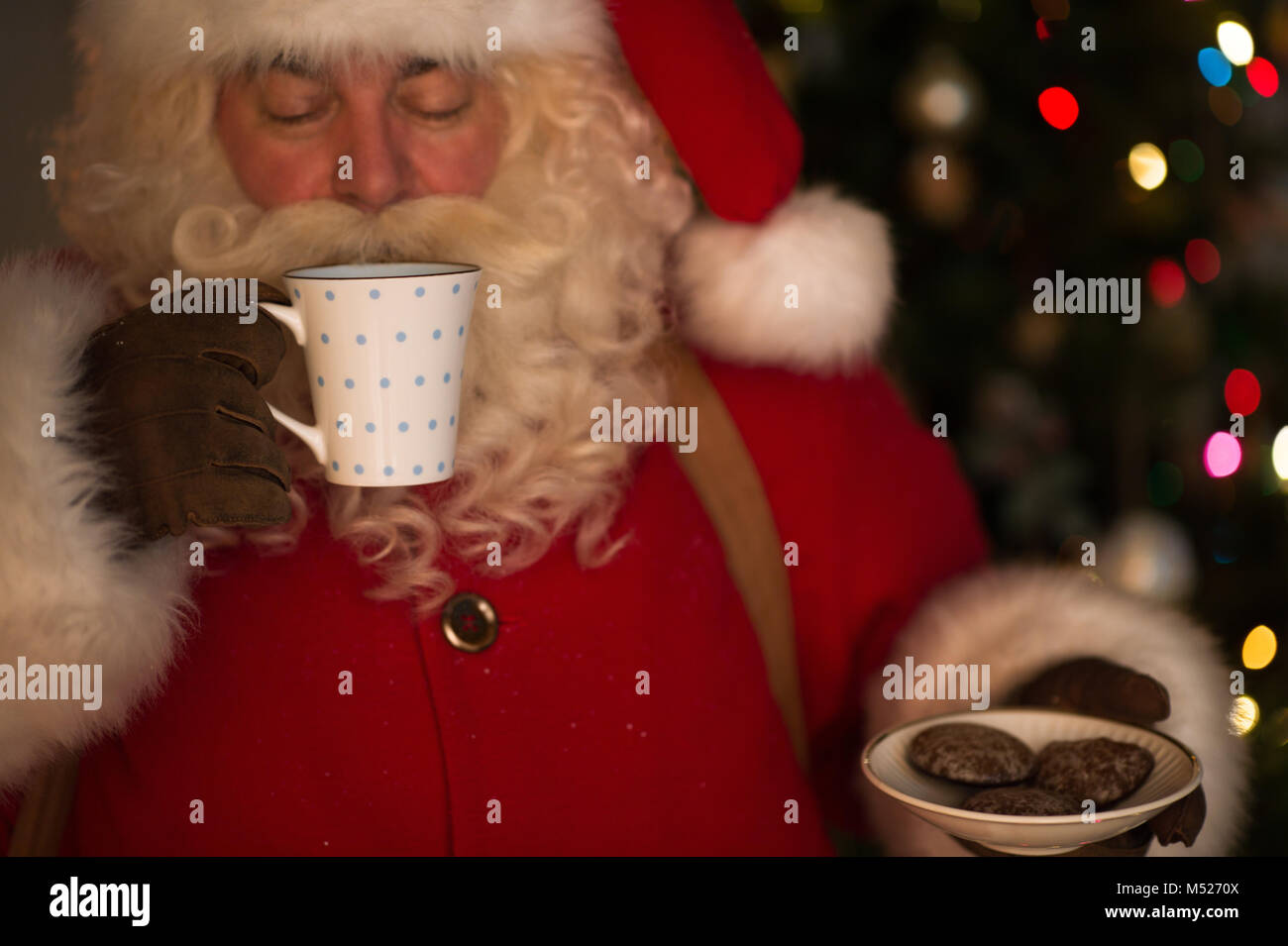 Santa Claus at Home eating cookies and drinking milk Stock Photo - Alamy