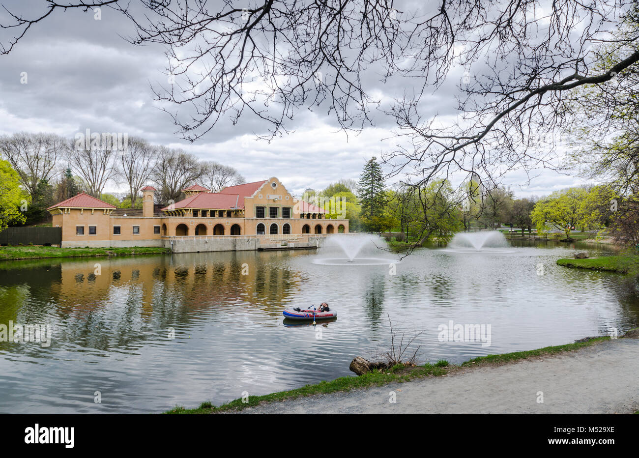A lone boater floats on lake in front of Spanish Revival Lake House ...