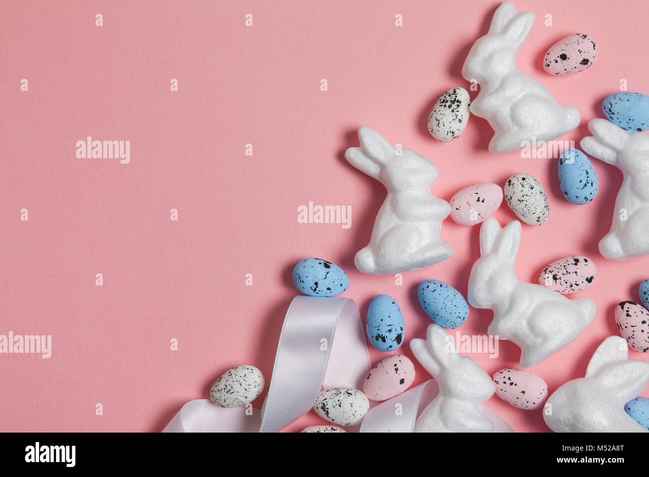 Pastel pink easter holiday background with eggs and easter bunnies ...