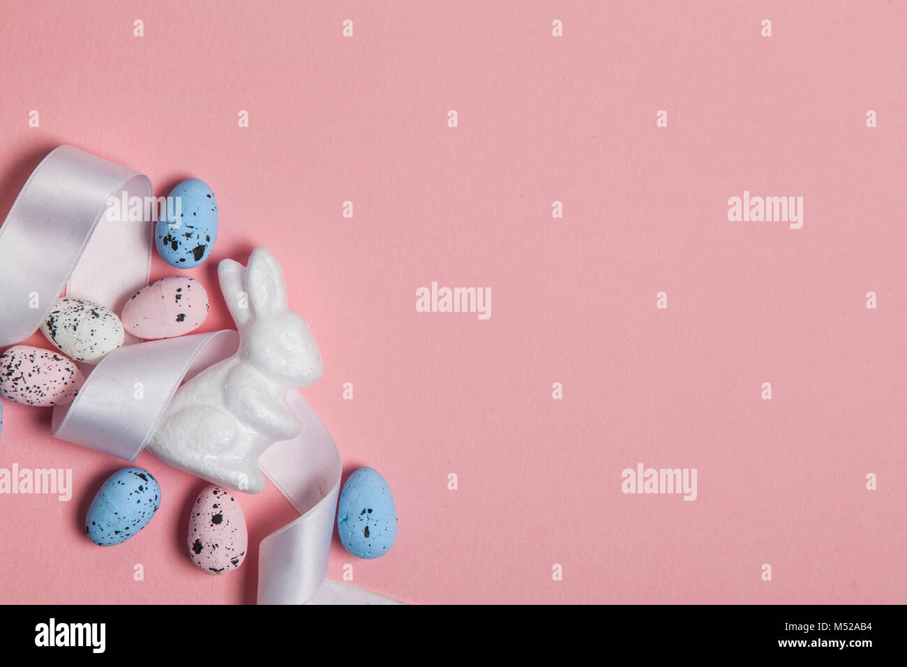 Pastel pink easter holiday background with eggs and easter bunnies ...