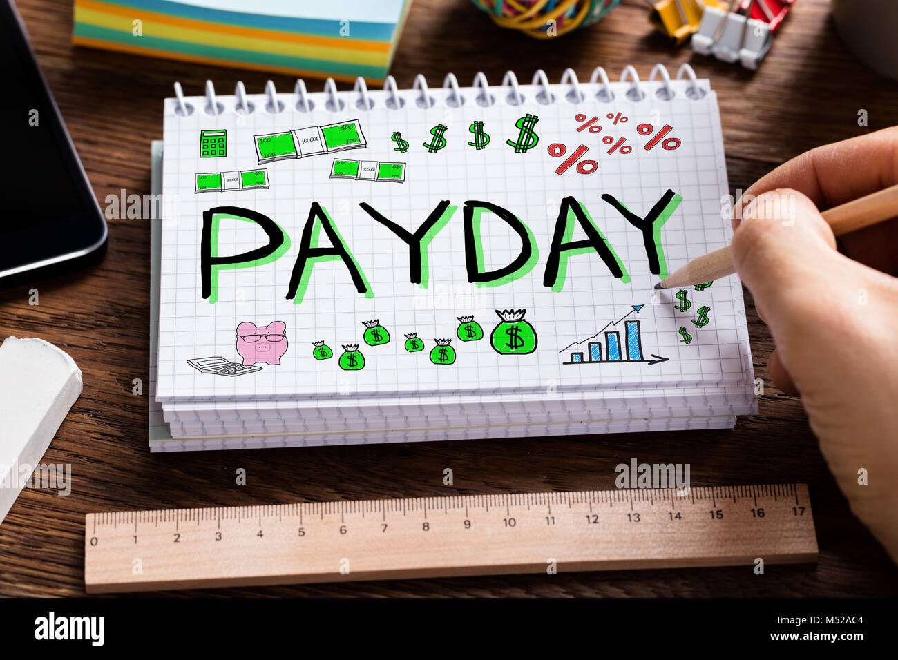 Man Drawing Payday Word In Notebook At Desk Stock Photo - Alamy