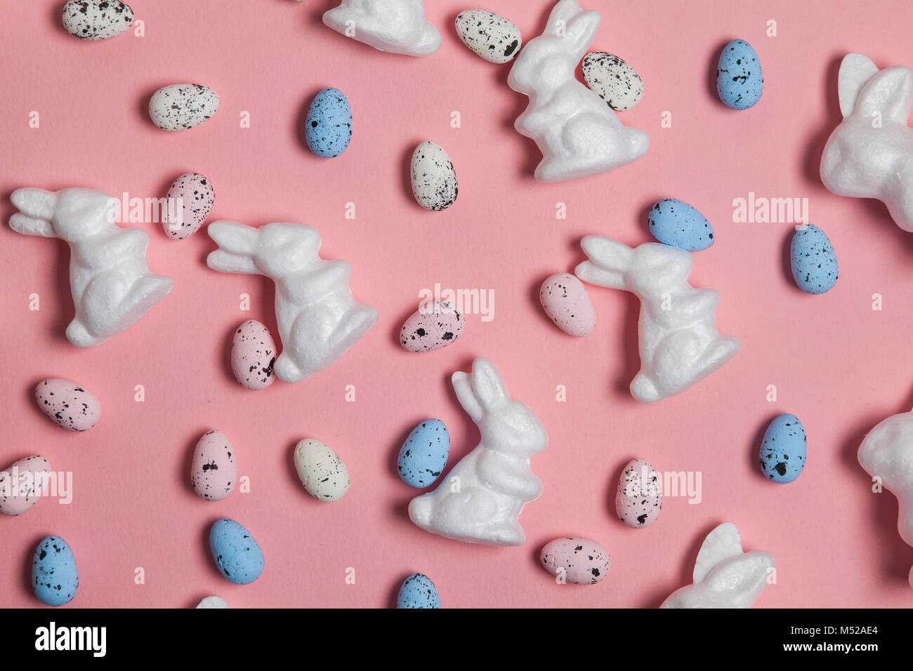 Pastel pink easter holiday background with eggs and easter bunnies ...