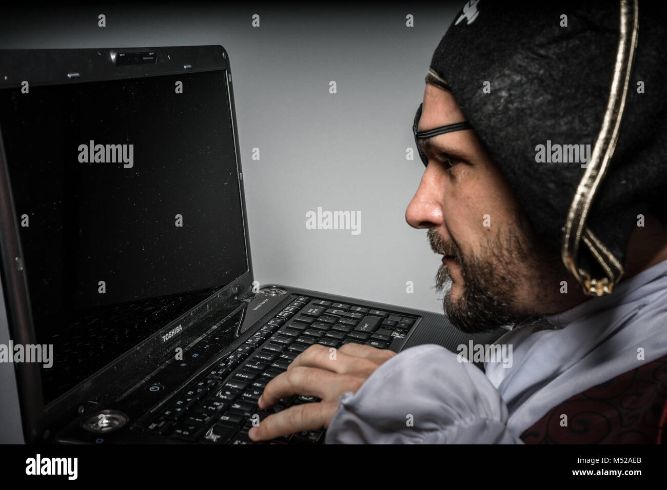 hacker, cyber criminal with pirate clothes, attempt to hack a laptop ...