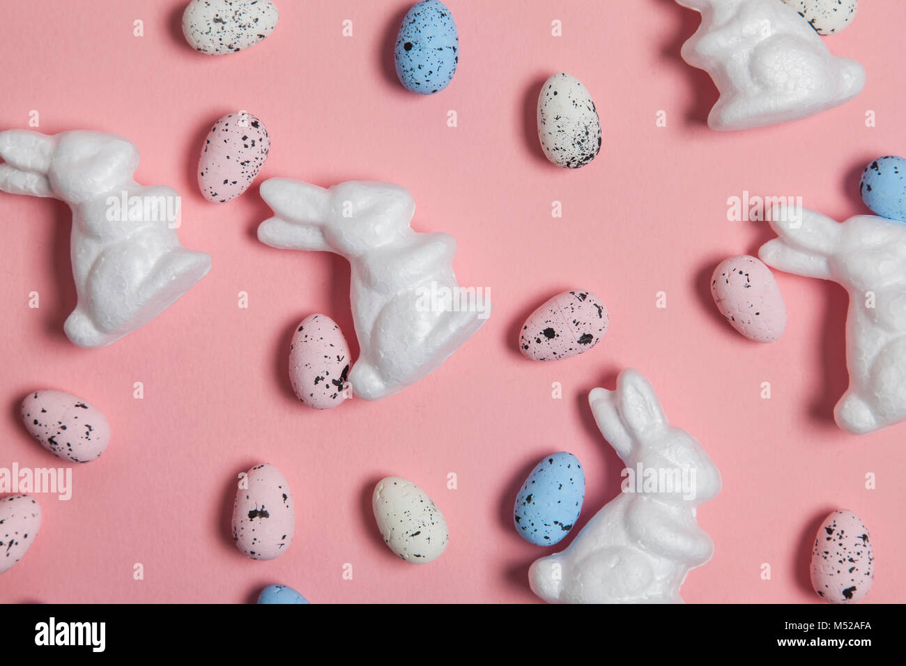 Pastel pink easter holiday background with eggs and easter bunnies ...