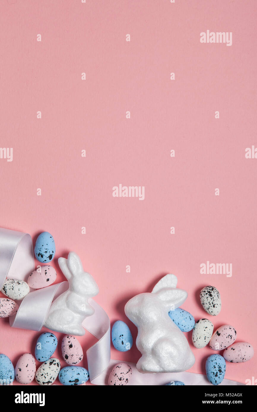 Pastel pink easter holiday background with eggs and easter bunnies ...