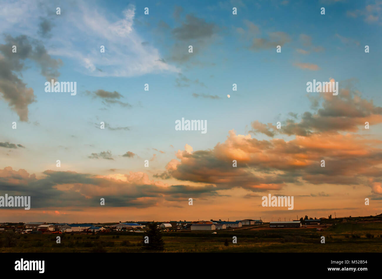 Orange and white clouds, illuminated by the rising sun, buildings and ...