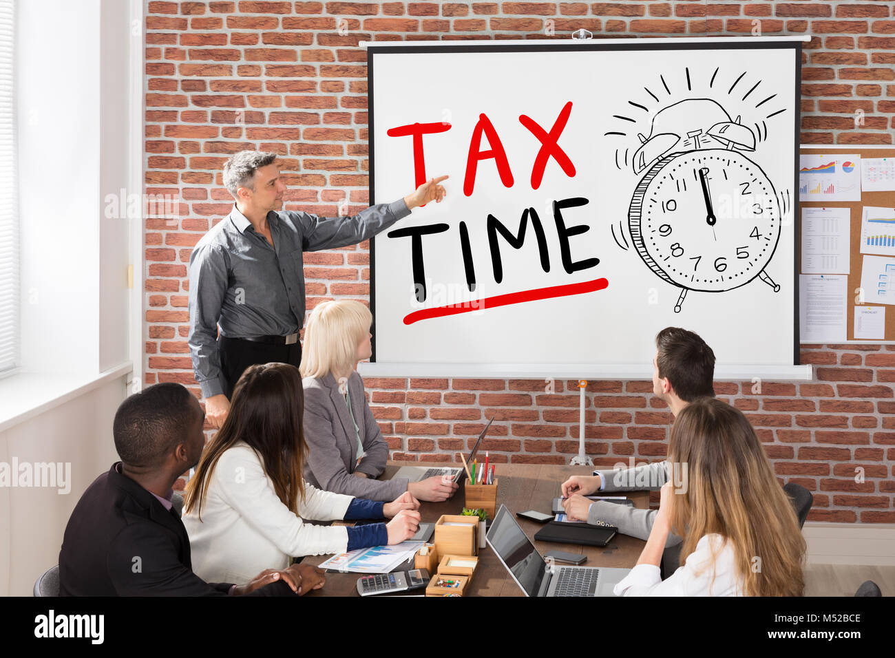 Man Giving Tax Time Presentation To Group Of People Stock Photo - Alamy