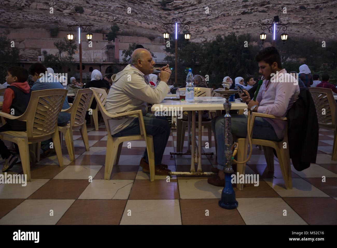 Families eat and smoke in a restaurant in Al Rabwah, Damascus. Despite ...
