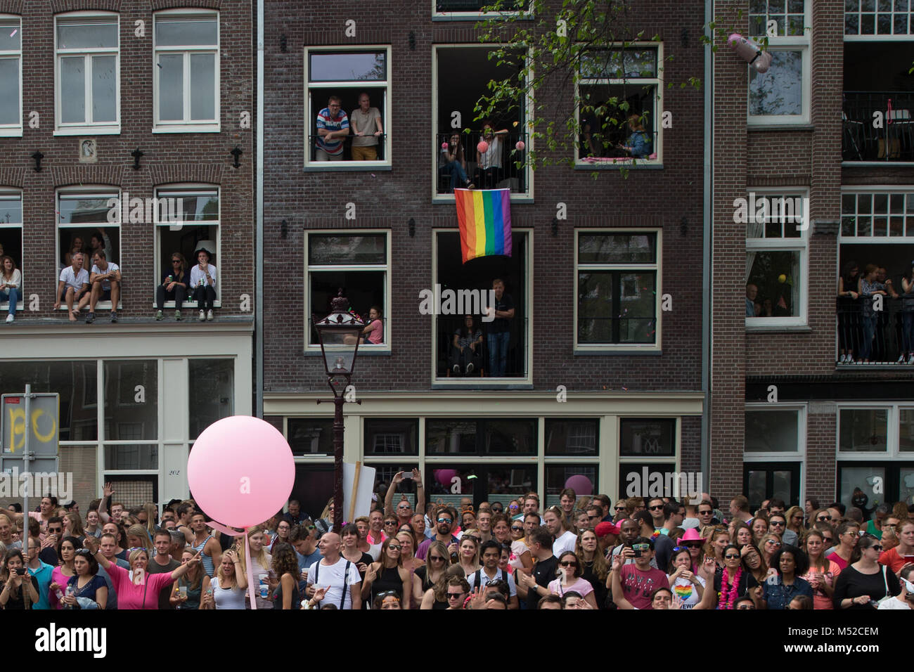 A rainbow flag being displayed on one of the buildings along the parade ...
