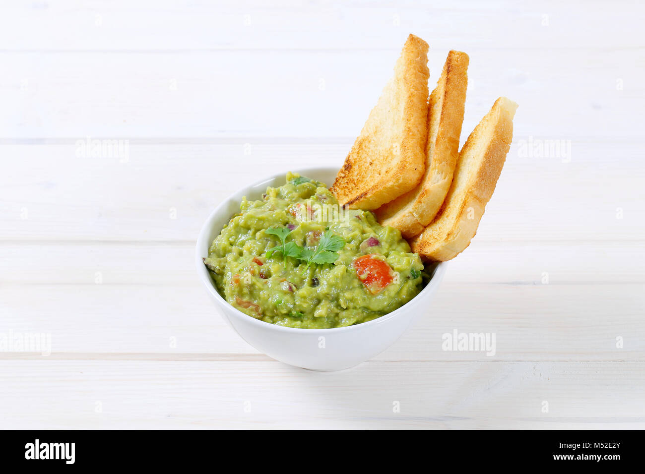 bowl of guacamole with toast bread on white background Stock Photo - Alamy