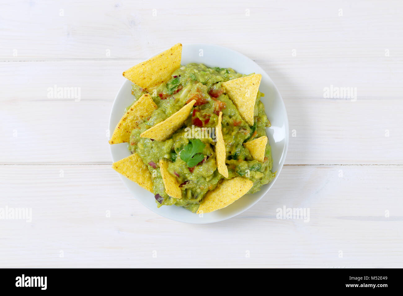 plate of guacamole with corn tortilla chips on white background Stock ...
