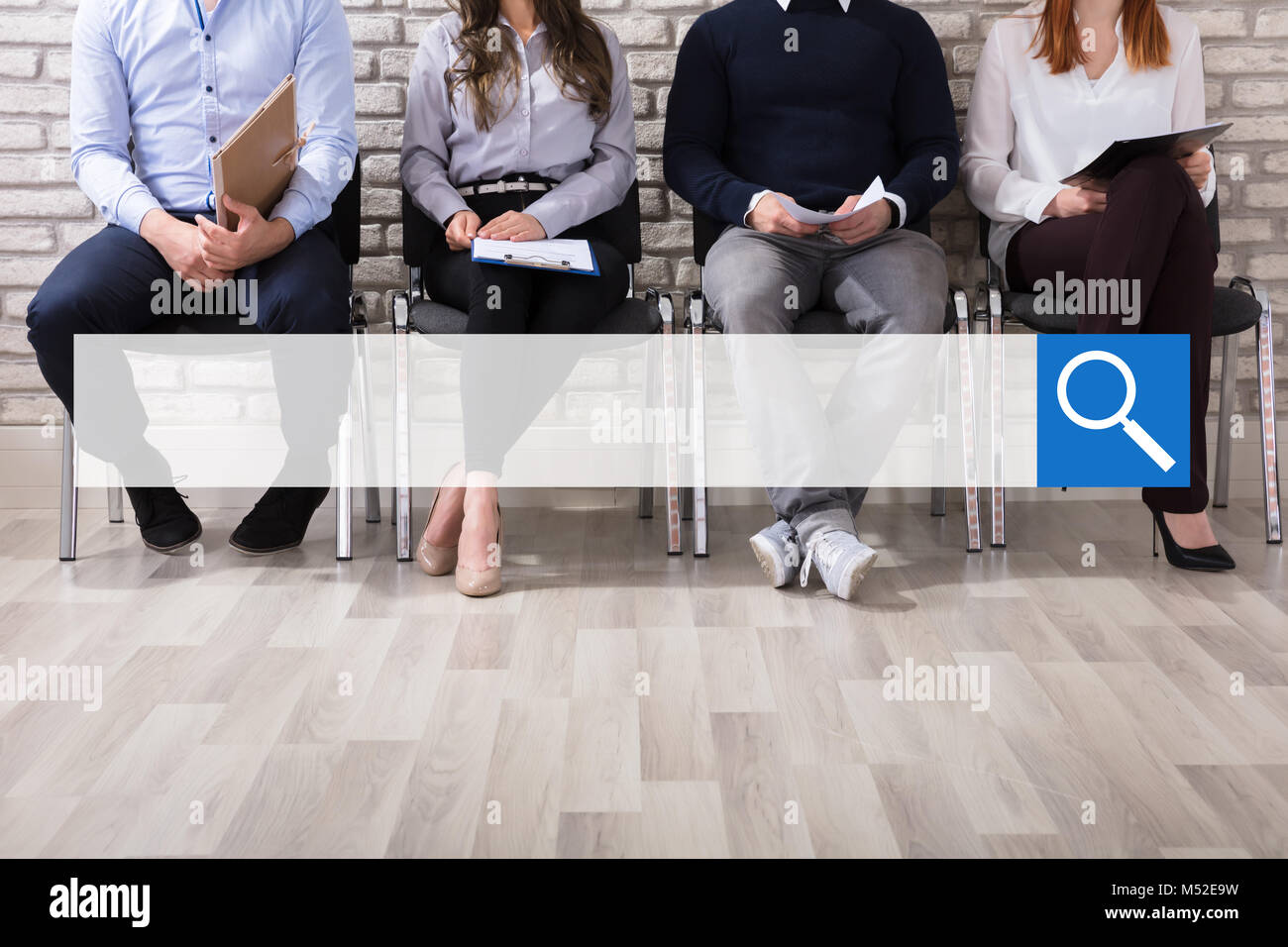 Male And Female Applicant Sitting On Chair Waiting For Interview Behind ...