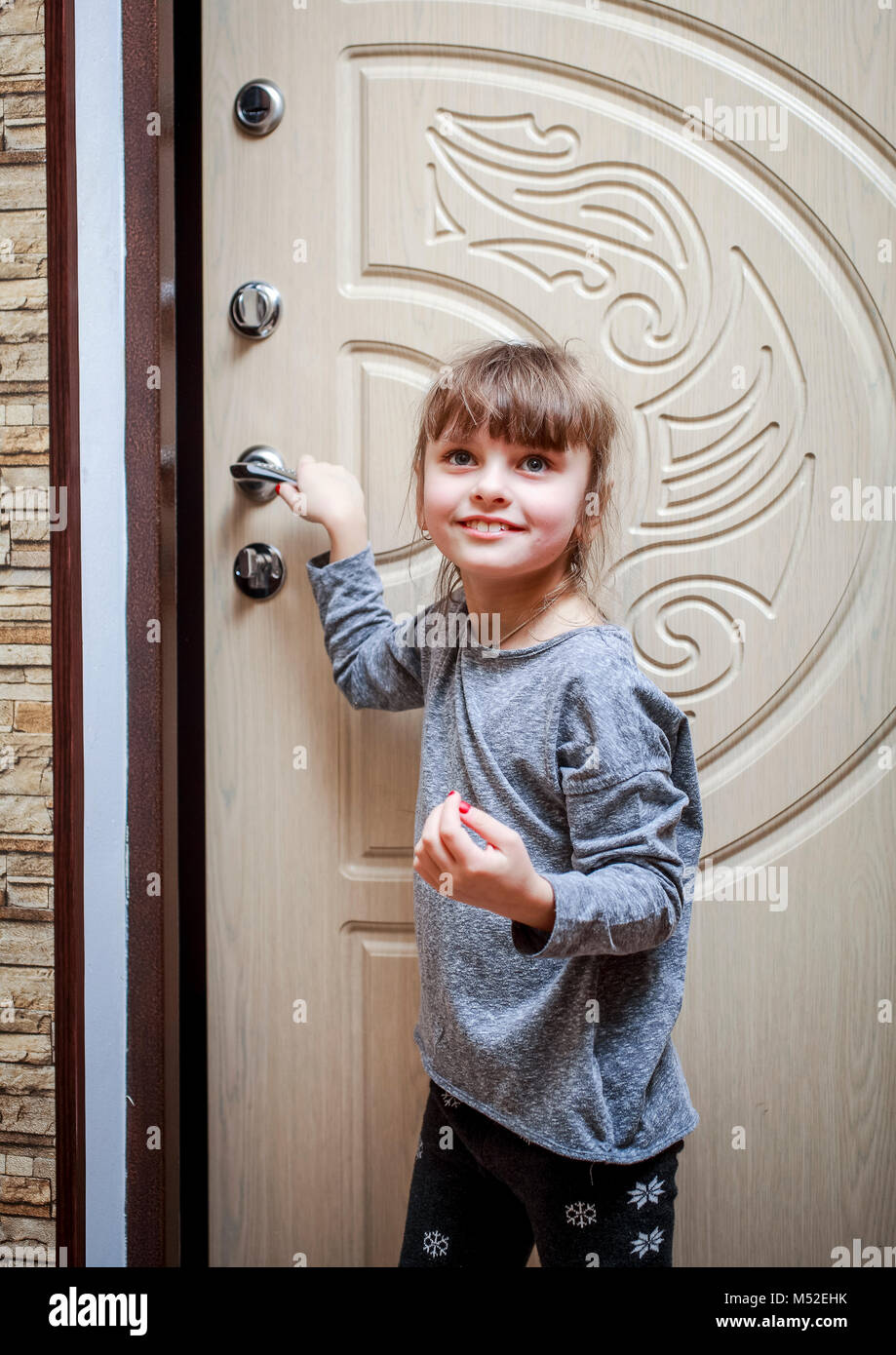Cute little girl closes the door of his apartment Stock Photo - Alamy