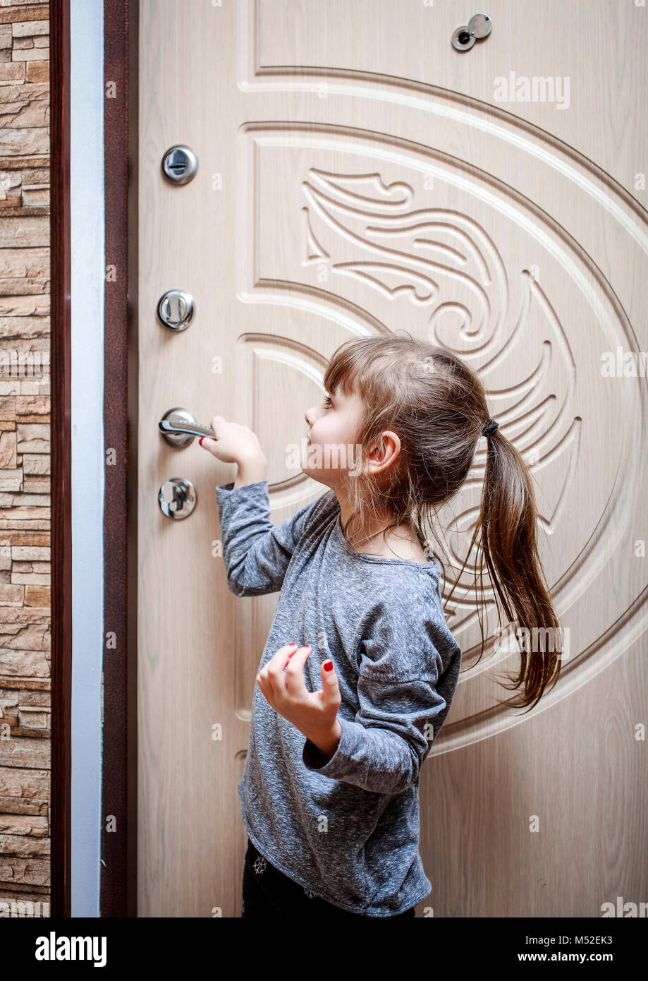 Cute little girl slammed the door of his apartment Stock Photo - Alamy