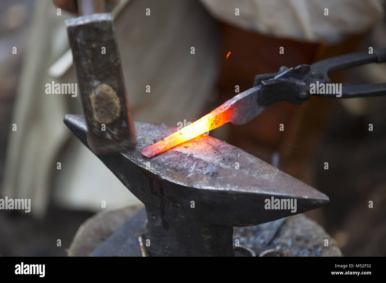 Blacksmith hammering hot metal arrow Stock Photo - Alamy