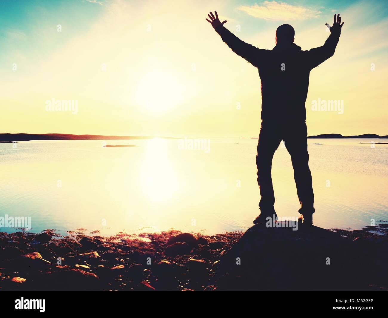 Man at sea. The sky and the man are reflected in a smooth water in ...