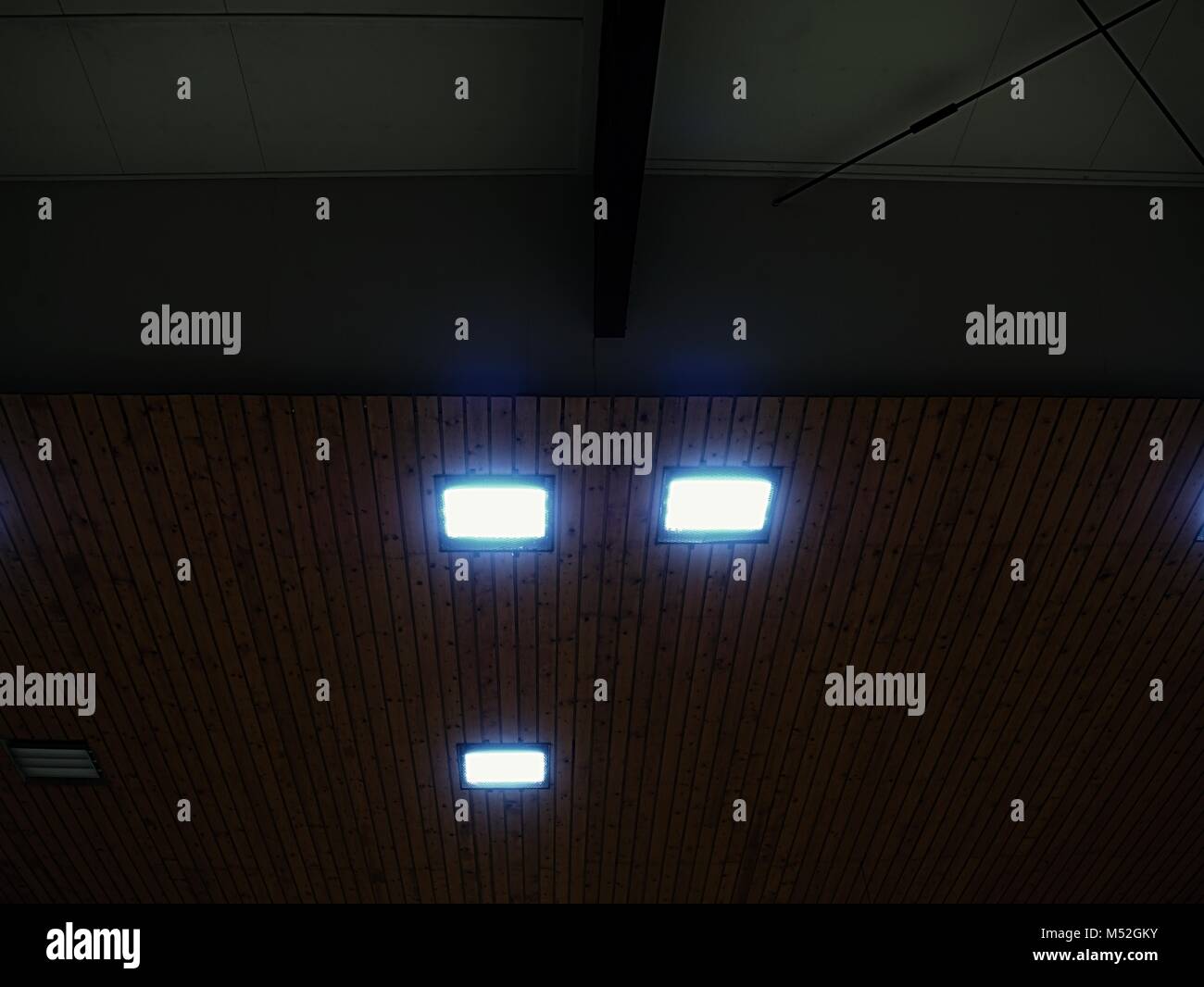 Luminous ceiling of square tiles. Wooden ceiling with lighting panels ...