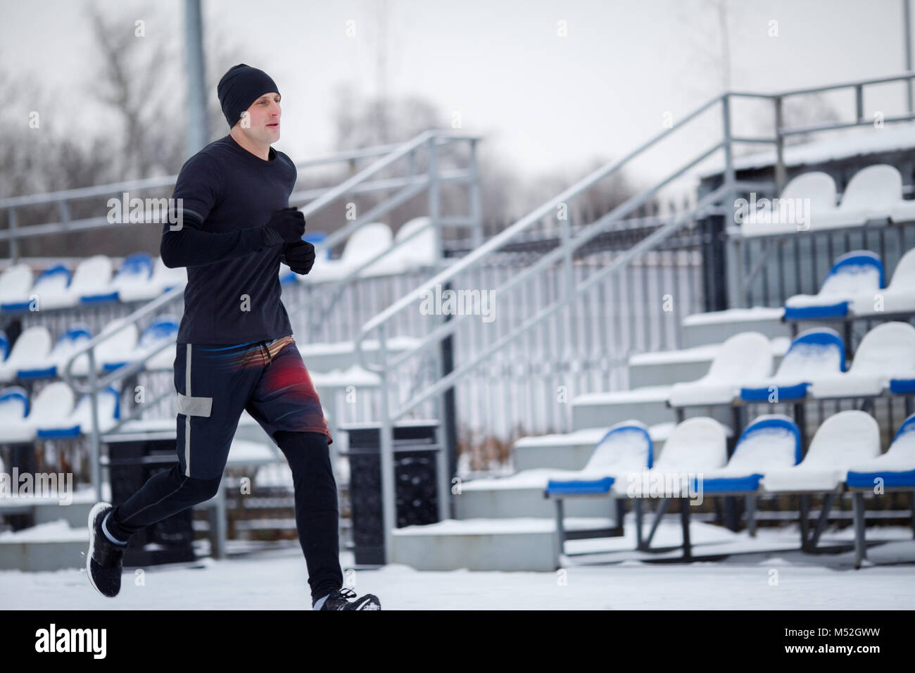 Image of running athlete in black clothes at stadium Stock Photo - Alamy