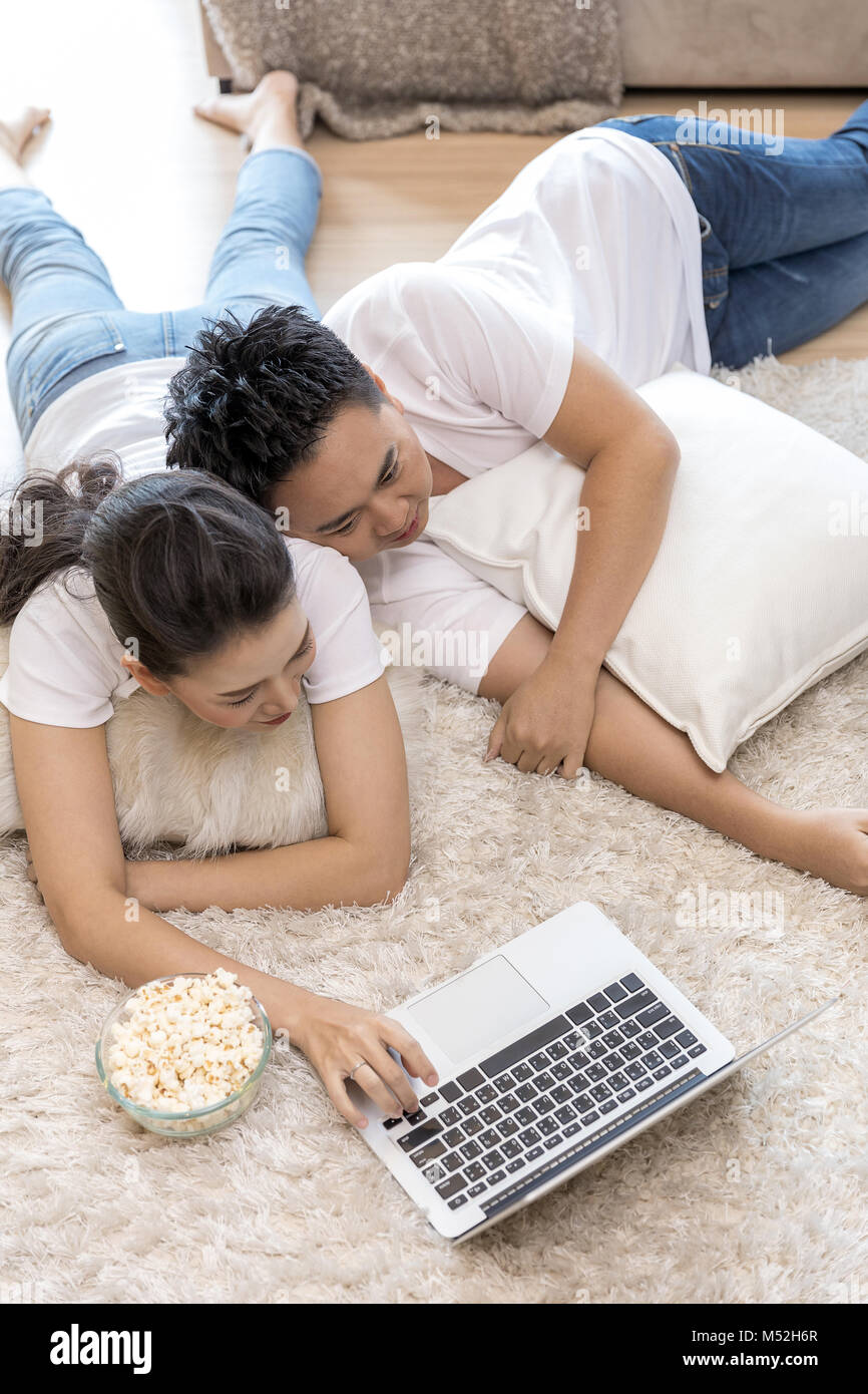 Couples lying down using laptop Stock Photo - Alamy