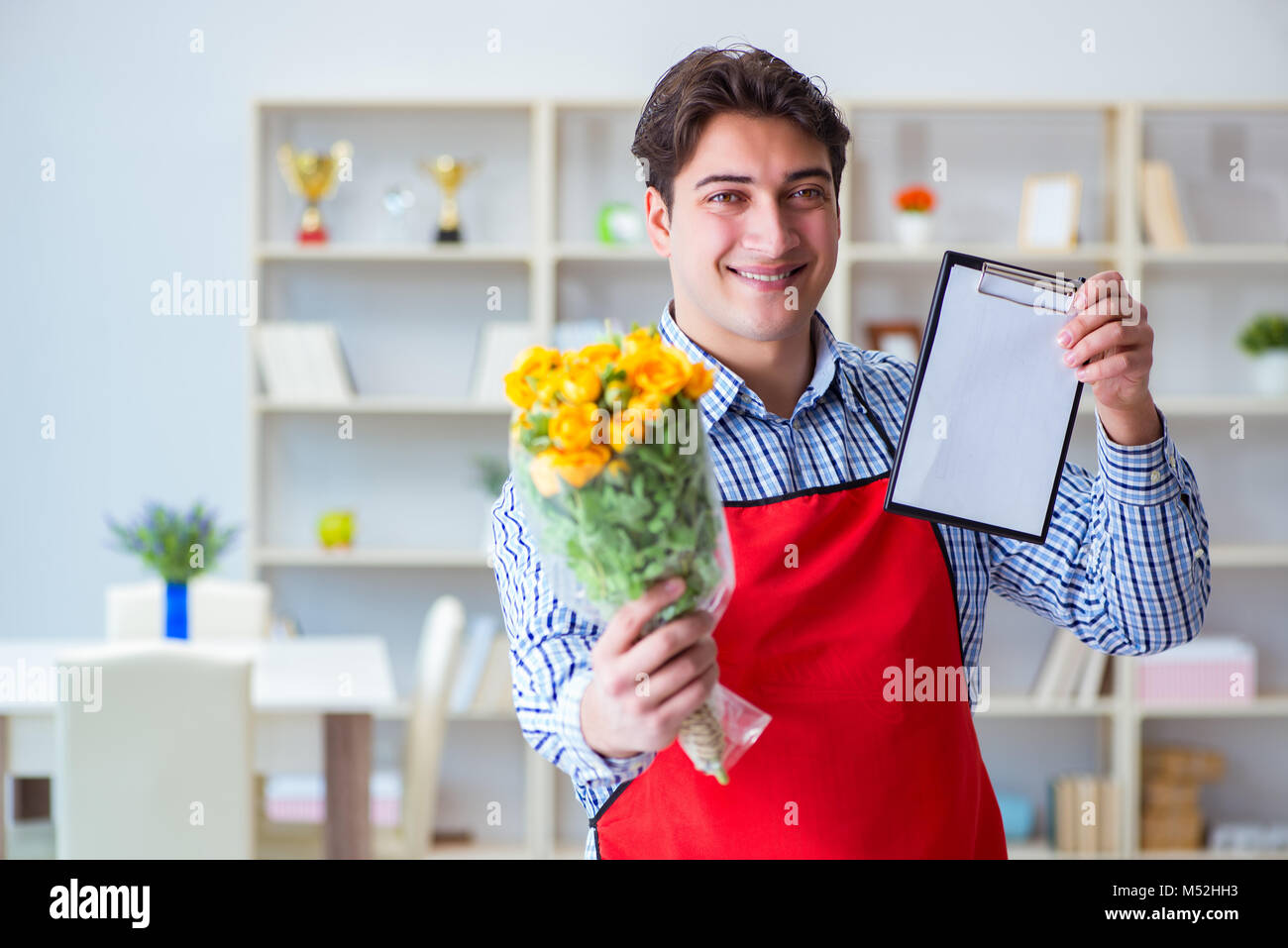 Flower shop assistant offering a bunch of flowers Stock Photo - Alamy