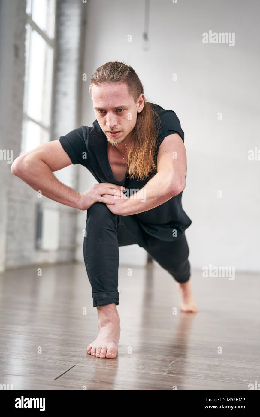 Young fit man stretching legs doing forward lunge Stock Photo - Alamy