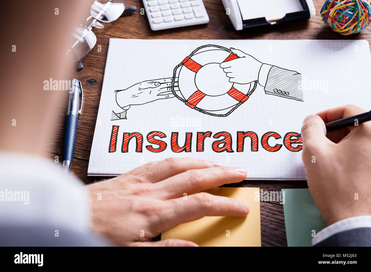 Close-up Of A Person Drawing Insurance Concept In Paper Grind On Desk ...