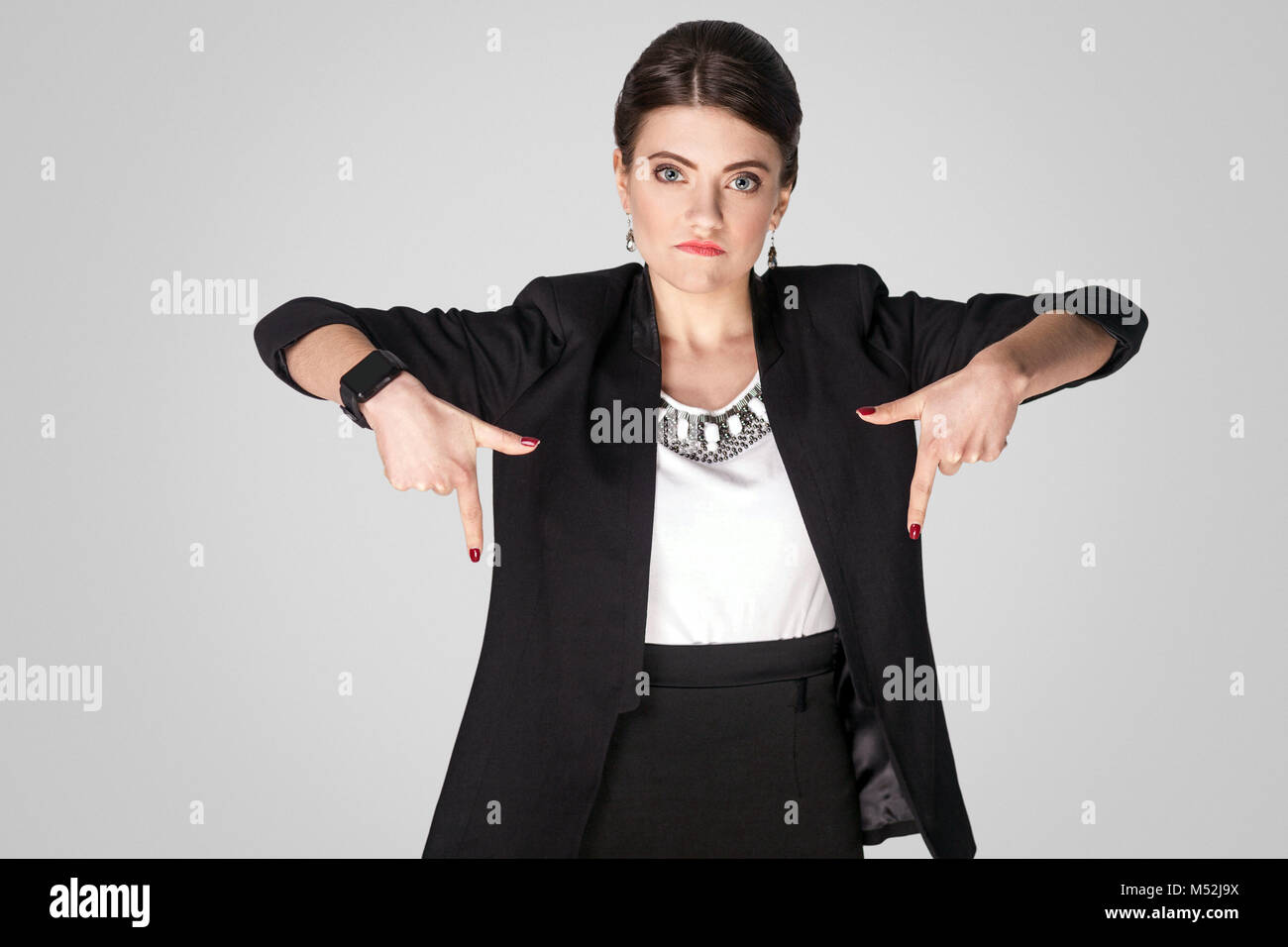 Looking down now! Seriously woman pointing finger down. Studio shot ...