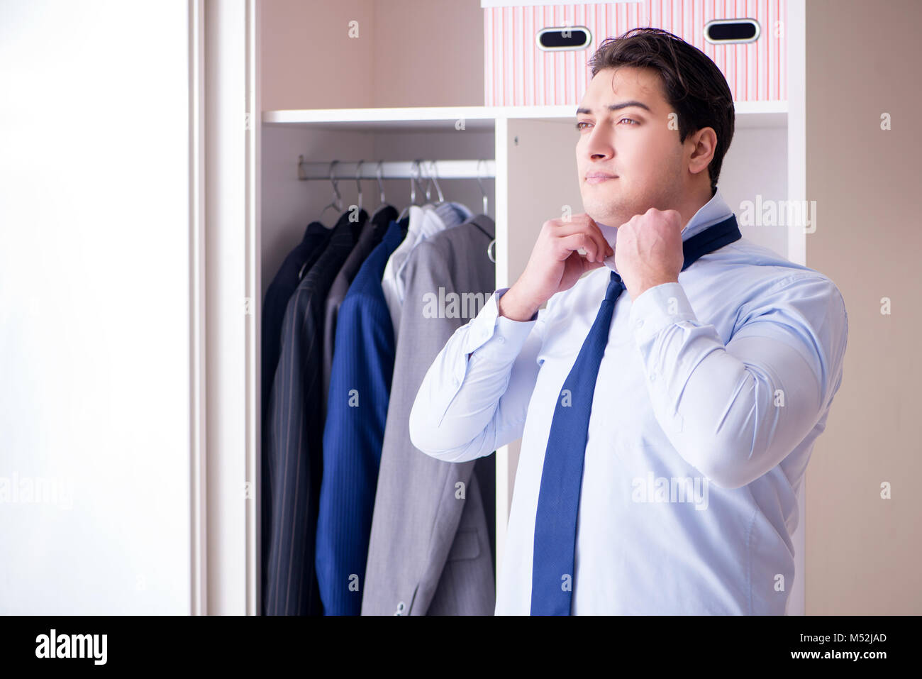 Young man businessman getting dressed for work Stock Photo - Alamy