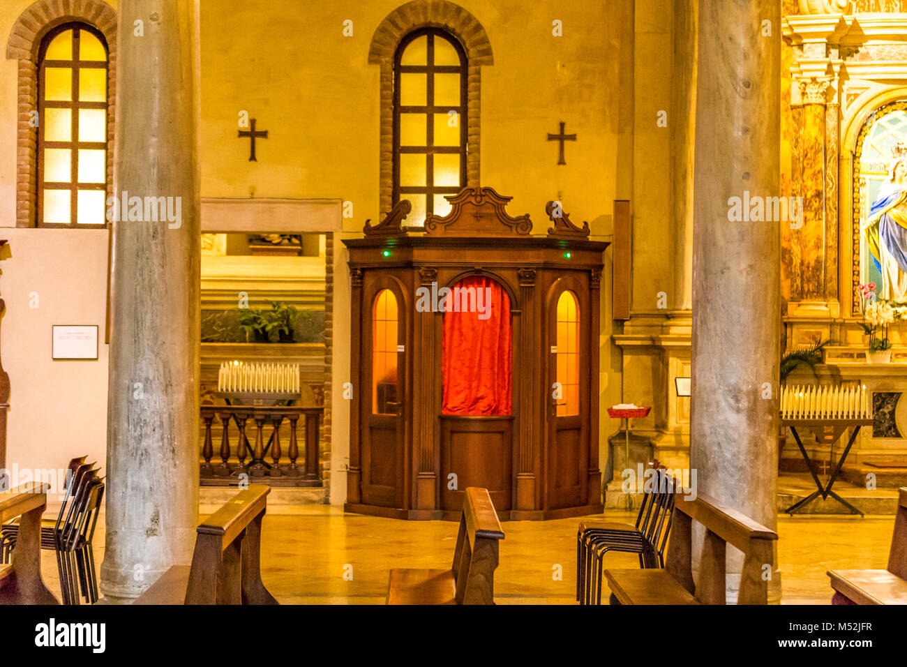 RAVENNA, ITALY - FEBRUARY 15, 2018: A priest waits for the penitent in ...