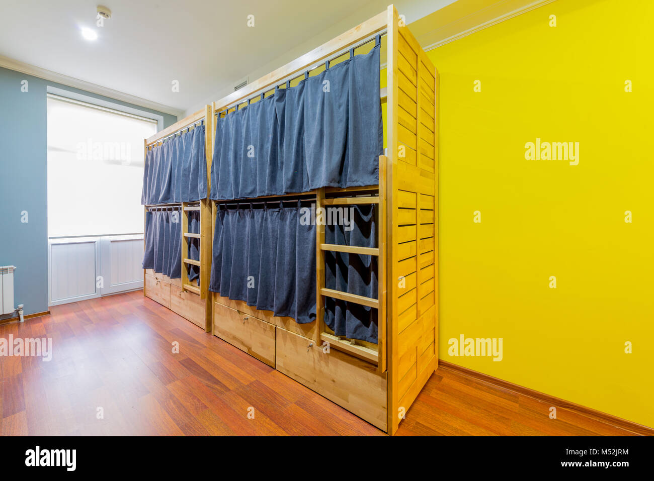 Hostel dormitory beds arranged in room Stock Photo - Alamy