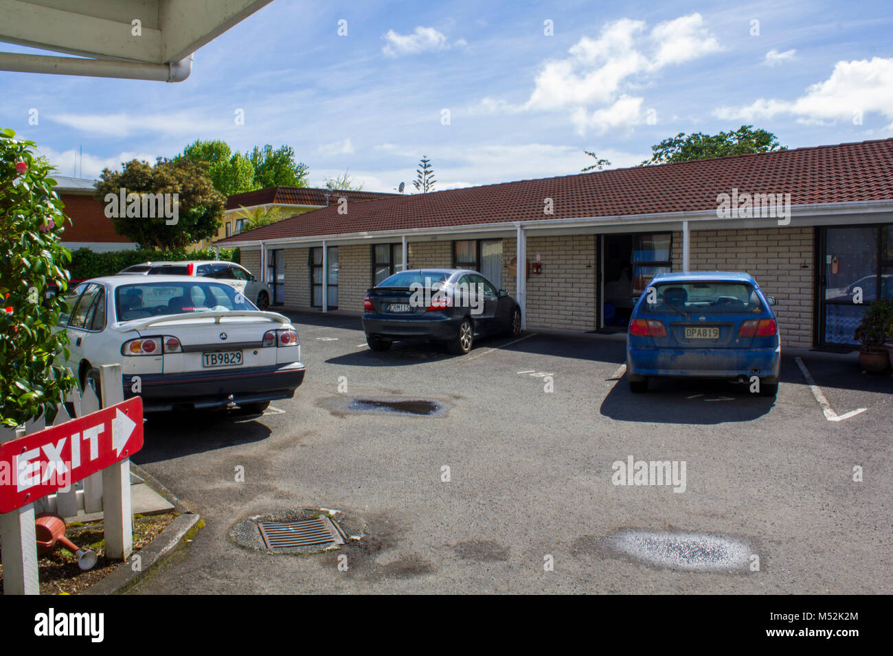 Cars parked at the entrance of motel rooms Stock Photo - Alamy