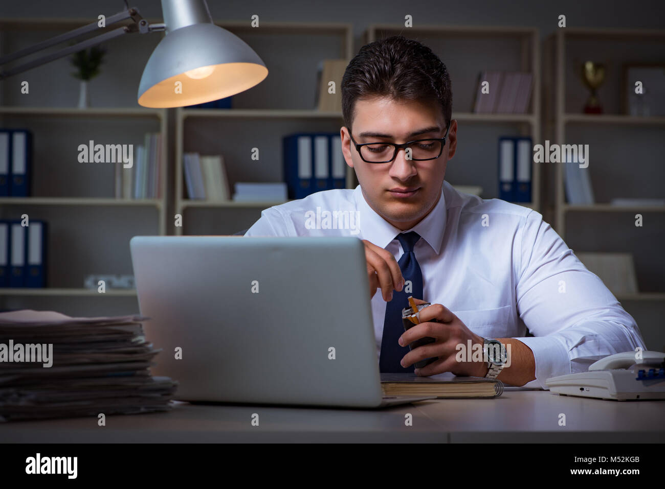 Businessman under stress smoking in office Stock Photo - Alamy