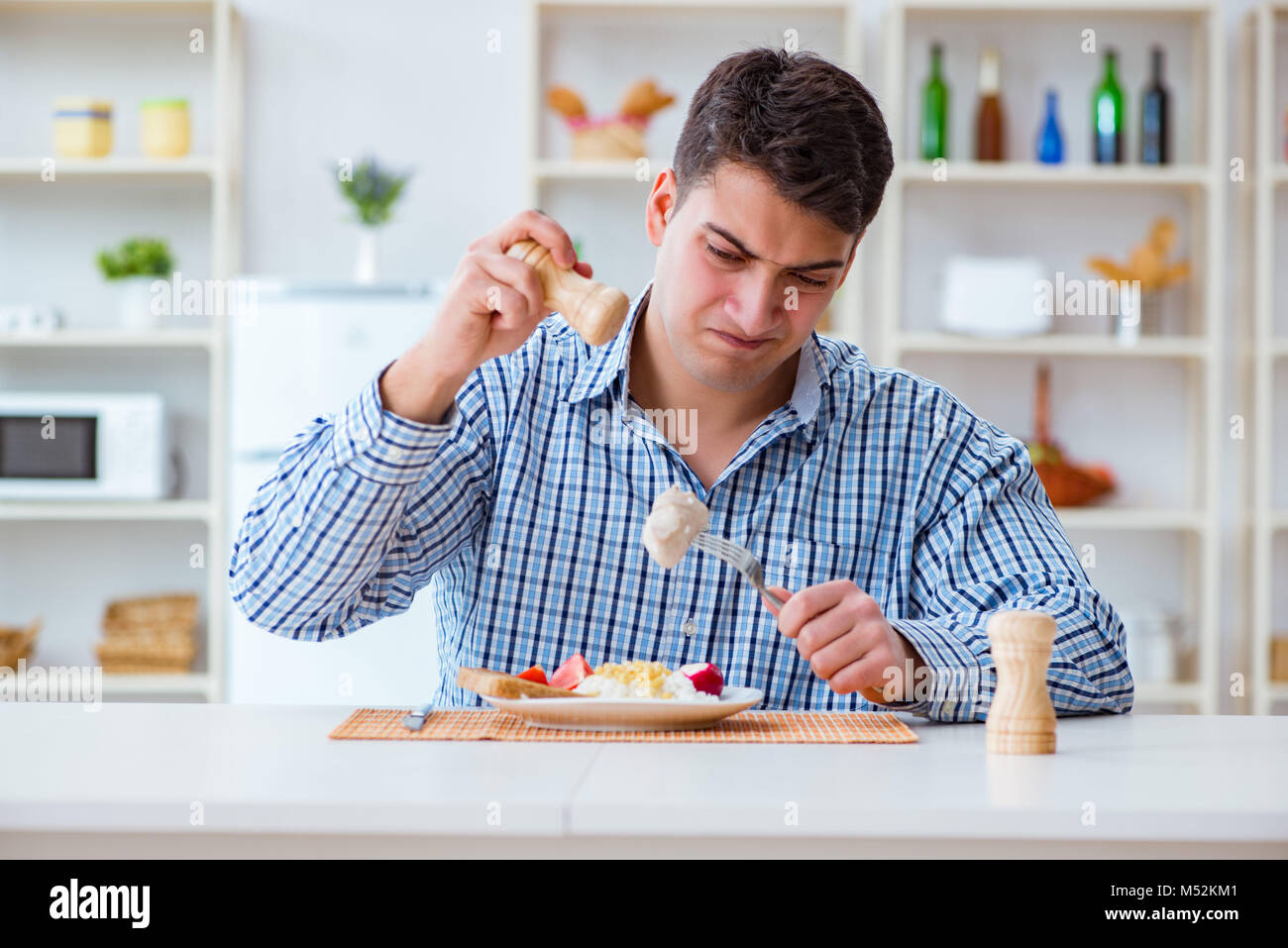 Man eating tasteless food at home for lunch Stock Photo - Alamy