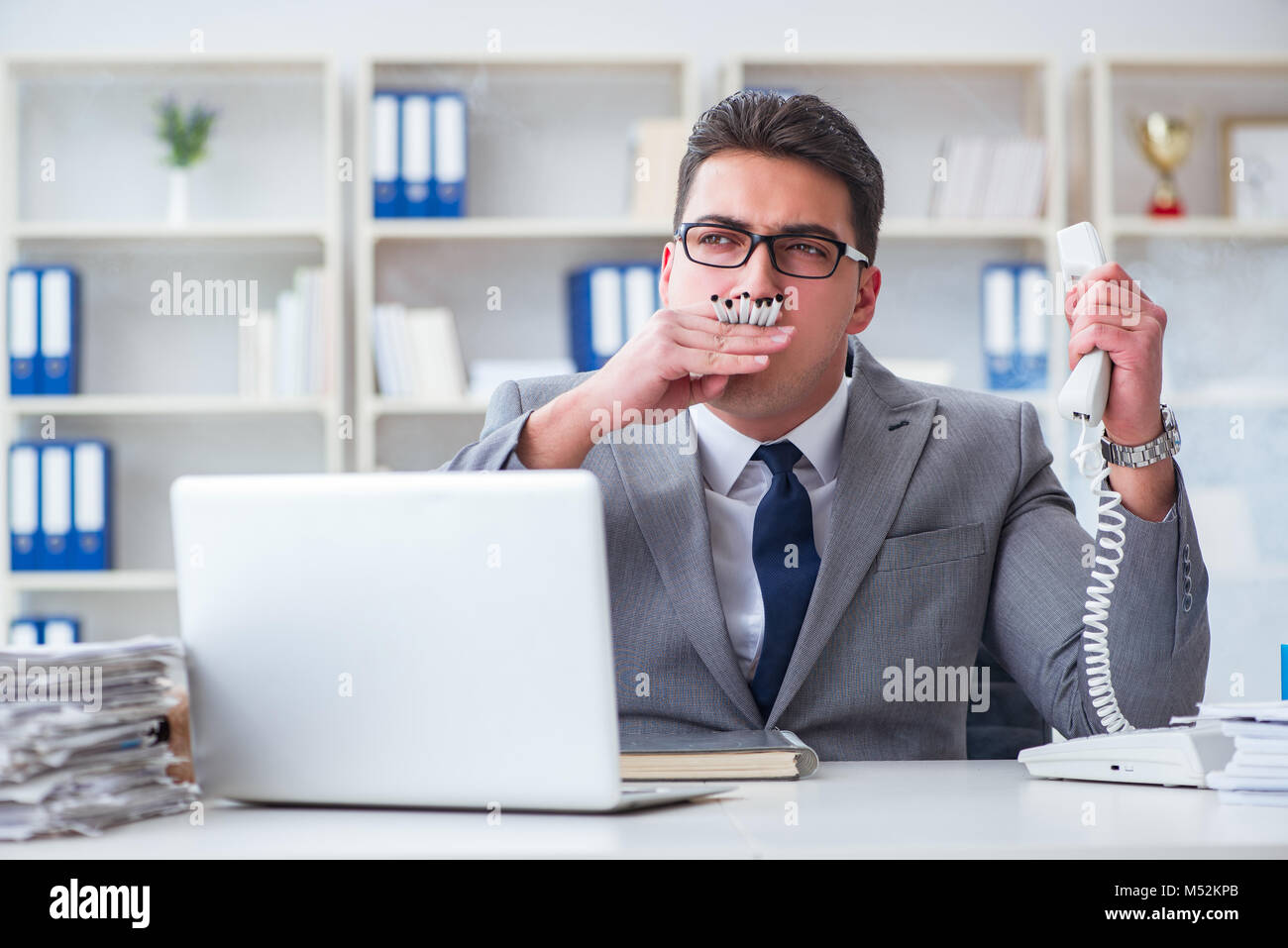 Businessman smoking in office at work Stock Photo - Alamy