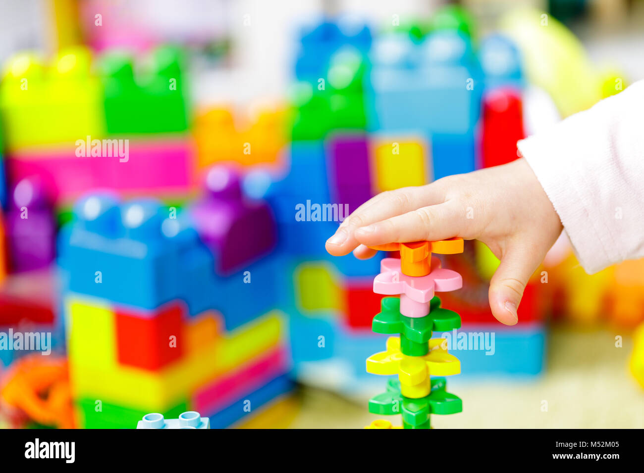 Children hand playing colorful plastic blocks. close up Stock Photo - Alamy