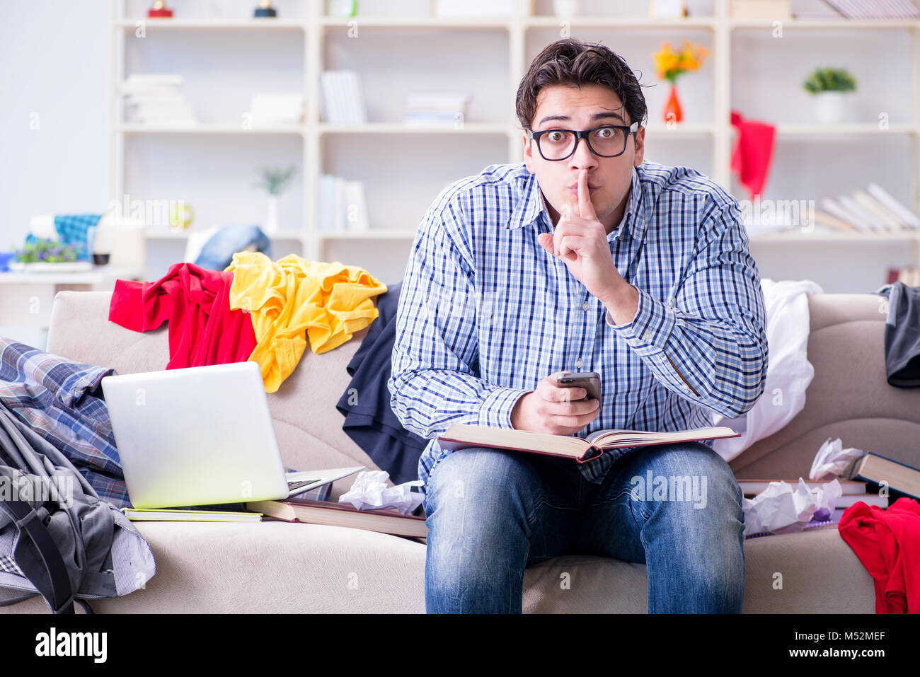 Young man working studying in messy room Stock Photo - Alamy
