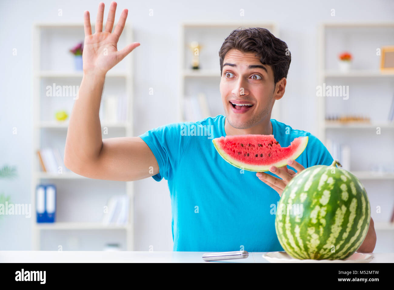 Man eating watermelon at home Stock Photo - Alamy