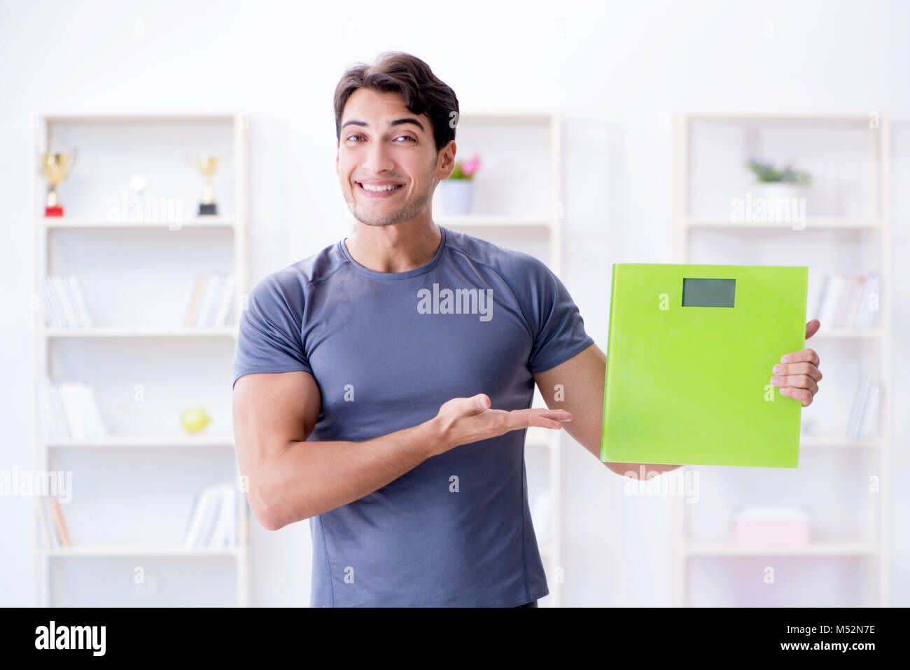 Man with scales in sports and health concept Stock Photo - Alamy