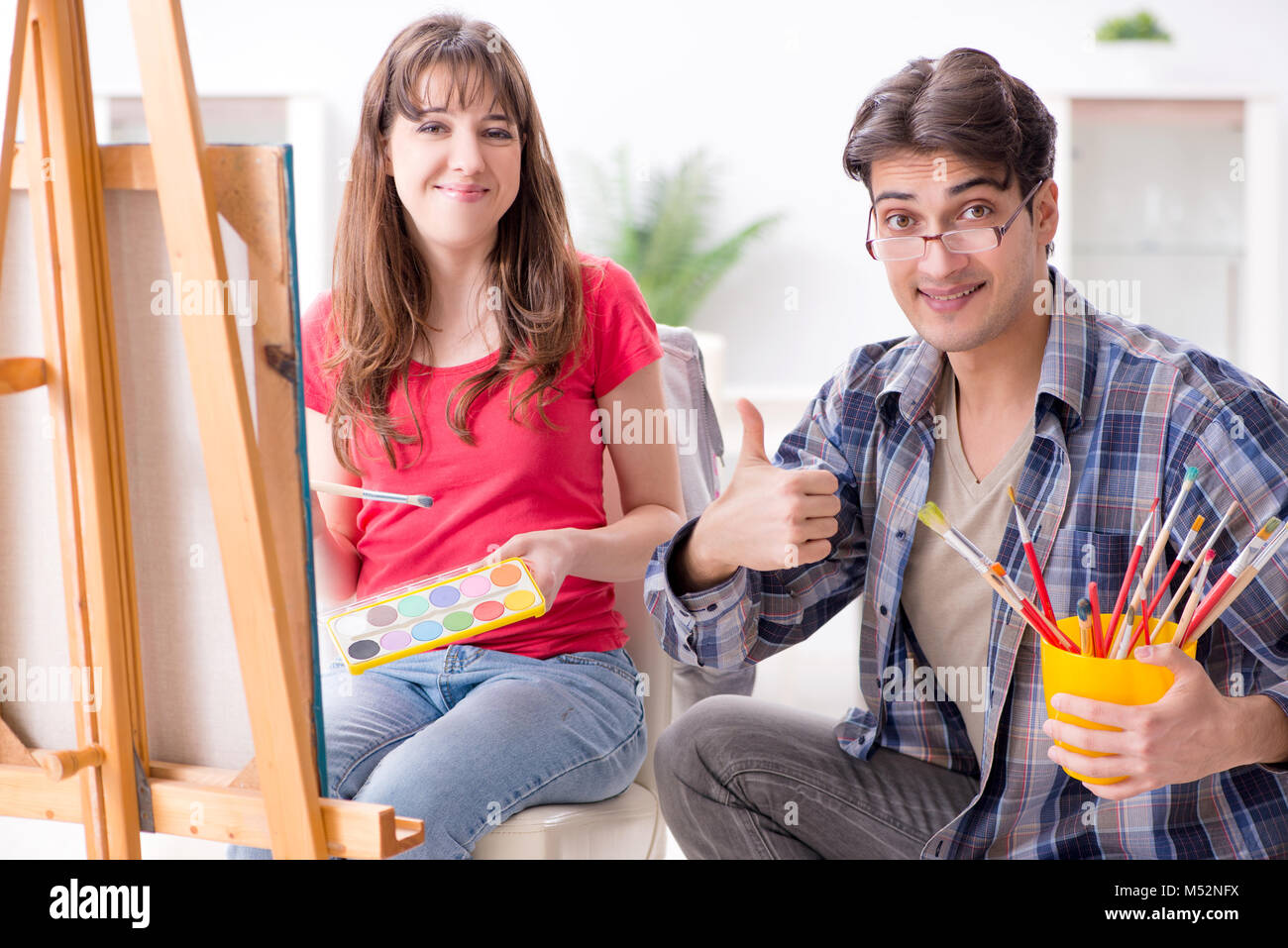 Artist coaching student in painting class in studio Stock Photo - Alamy