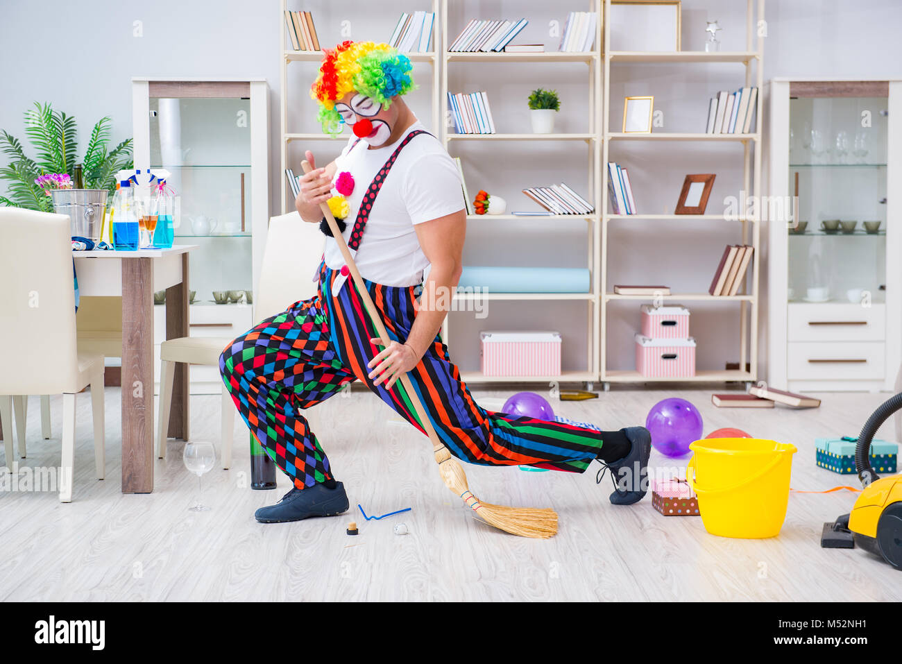 Funny clown doing cleaning at home Stock Photo - Alamy