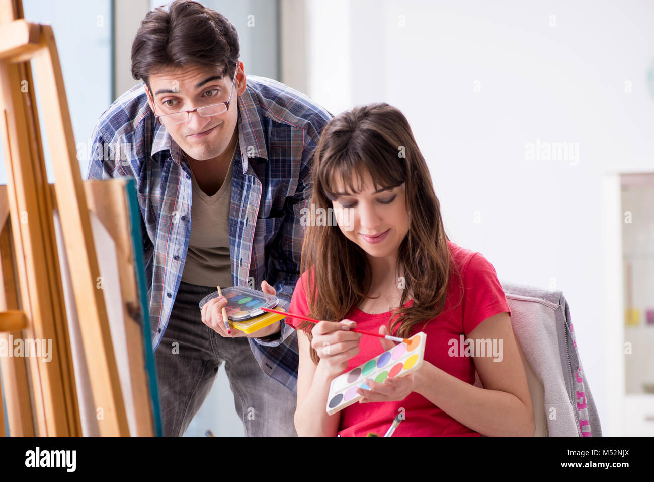 Artist coaching student in painting class in studio Stock Photo - Alamy