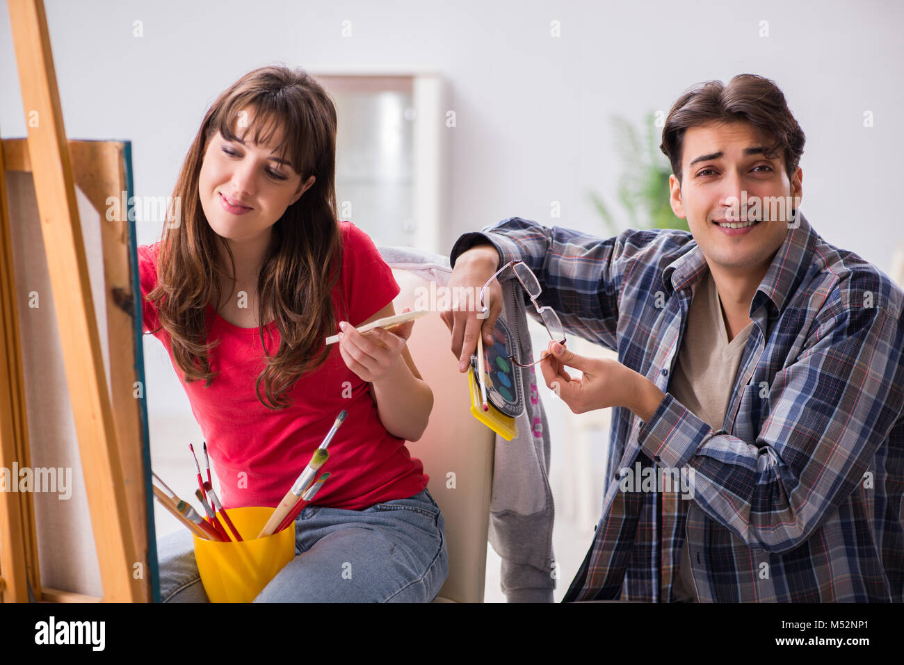 Artist coaching student in painting class in studio Stock Photo - Alamy