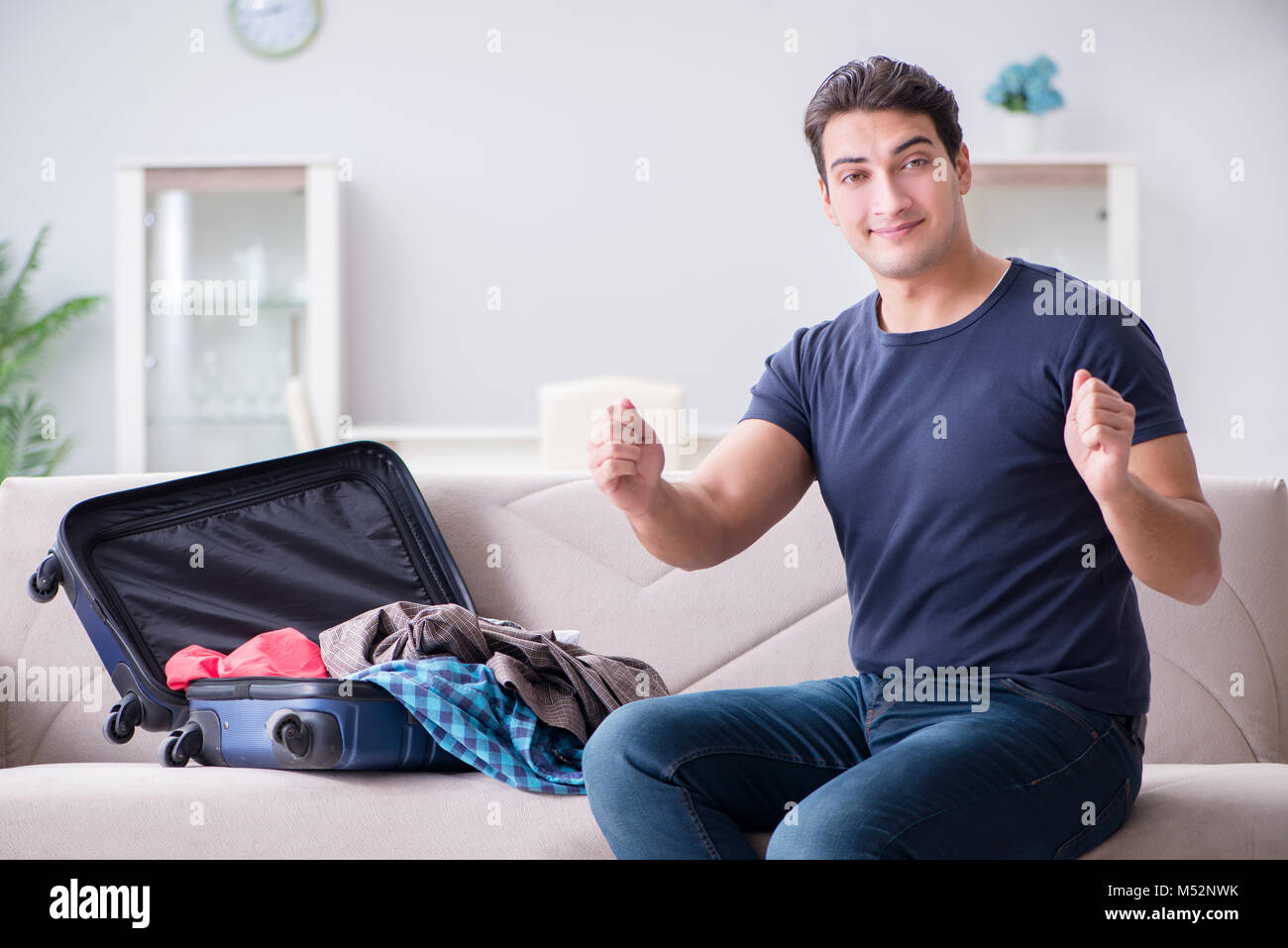 Young man preparing packing for summer vacation Stock Photo - Alamy