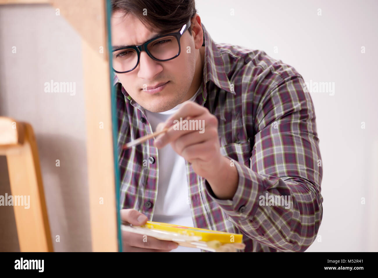 The young male artist drawing pictures in bright studio Stock Photo - Alamy