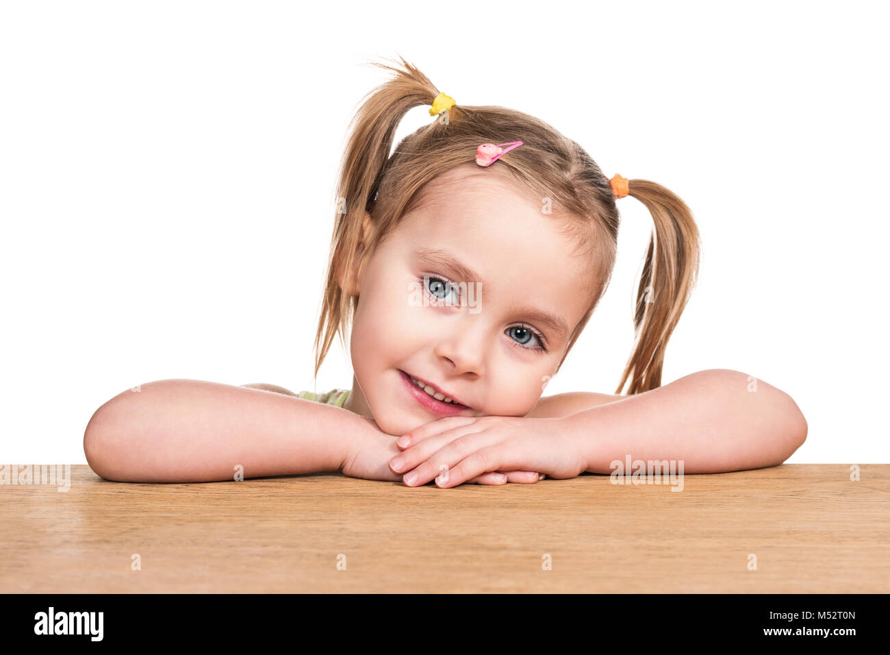 Portrait of a cute little girl lying on a table on her hands isolated ...