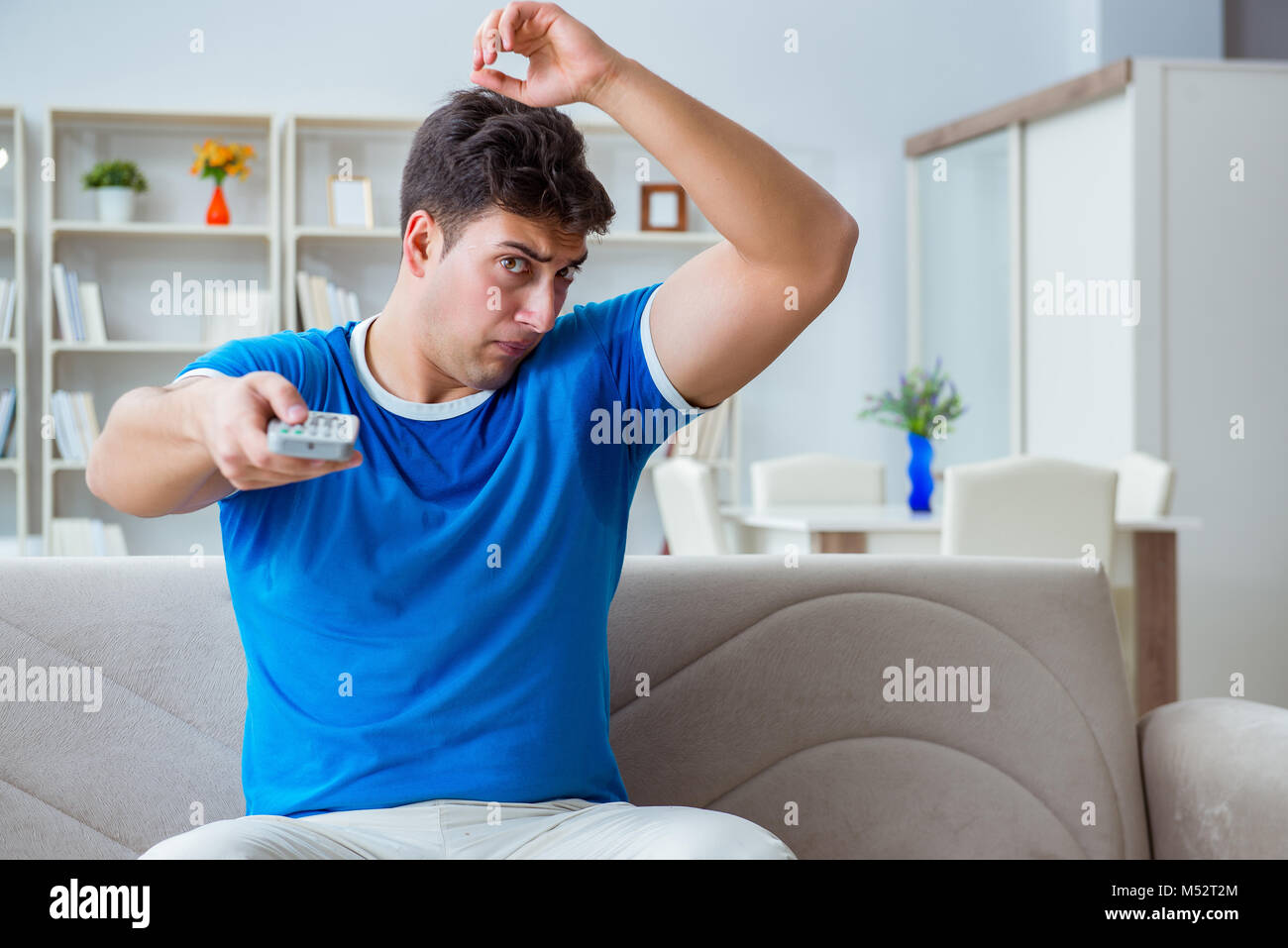 Man sweating excessively smelling bad at home Stock Photo - Alamy